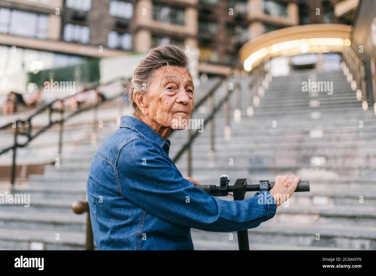 Cheerful elderly woman on a scooter. Grandma rides a scooter ...