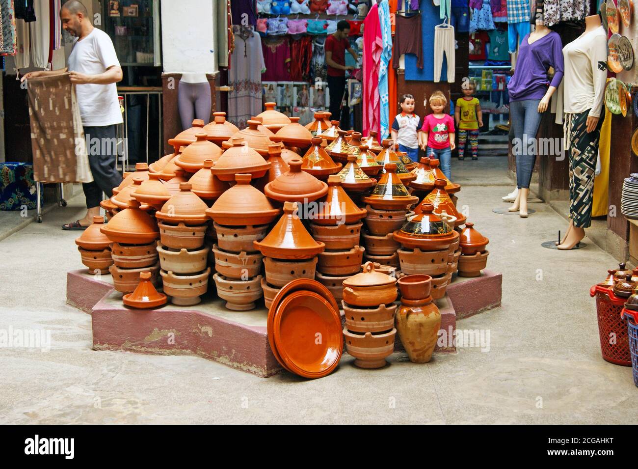 A stack of decorative and working tagine surrounded by other souvenirs ...