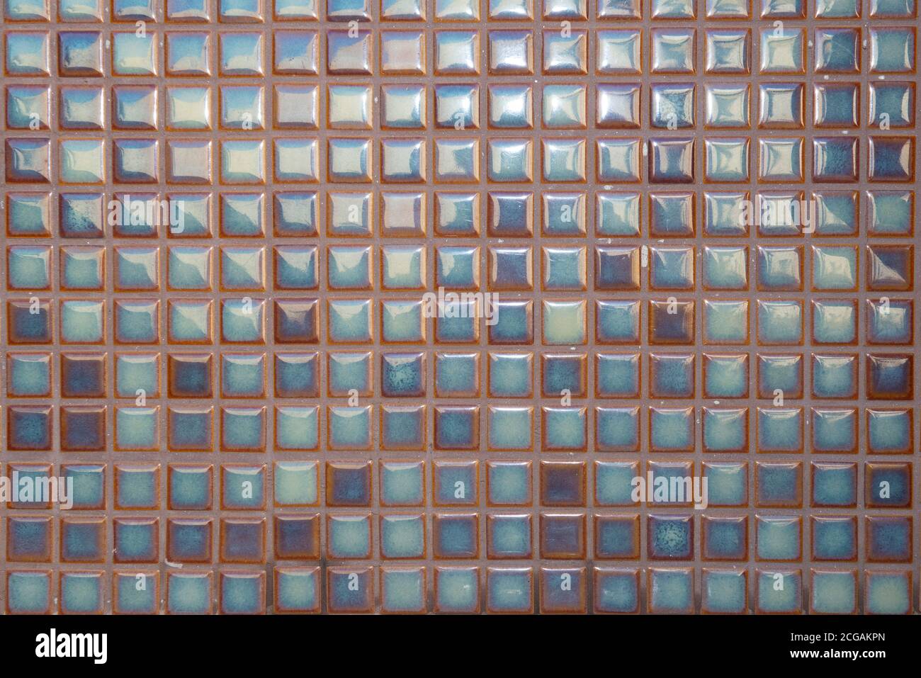Closeup shot of wall covered by bright blue square tiles. Shiny ...