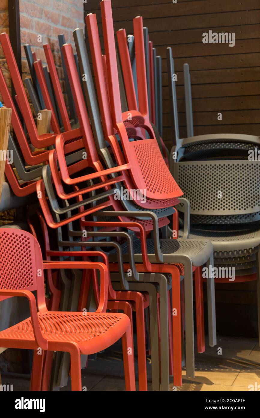 close up of several red and gray plastic chairs stacked one on top of ...
