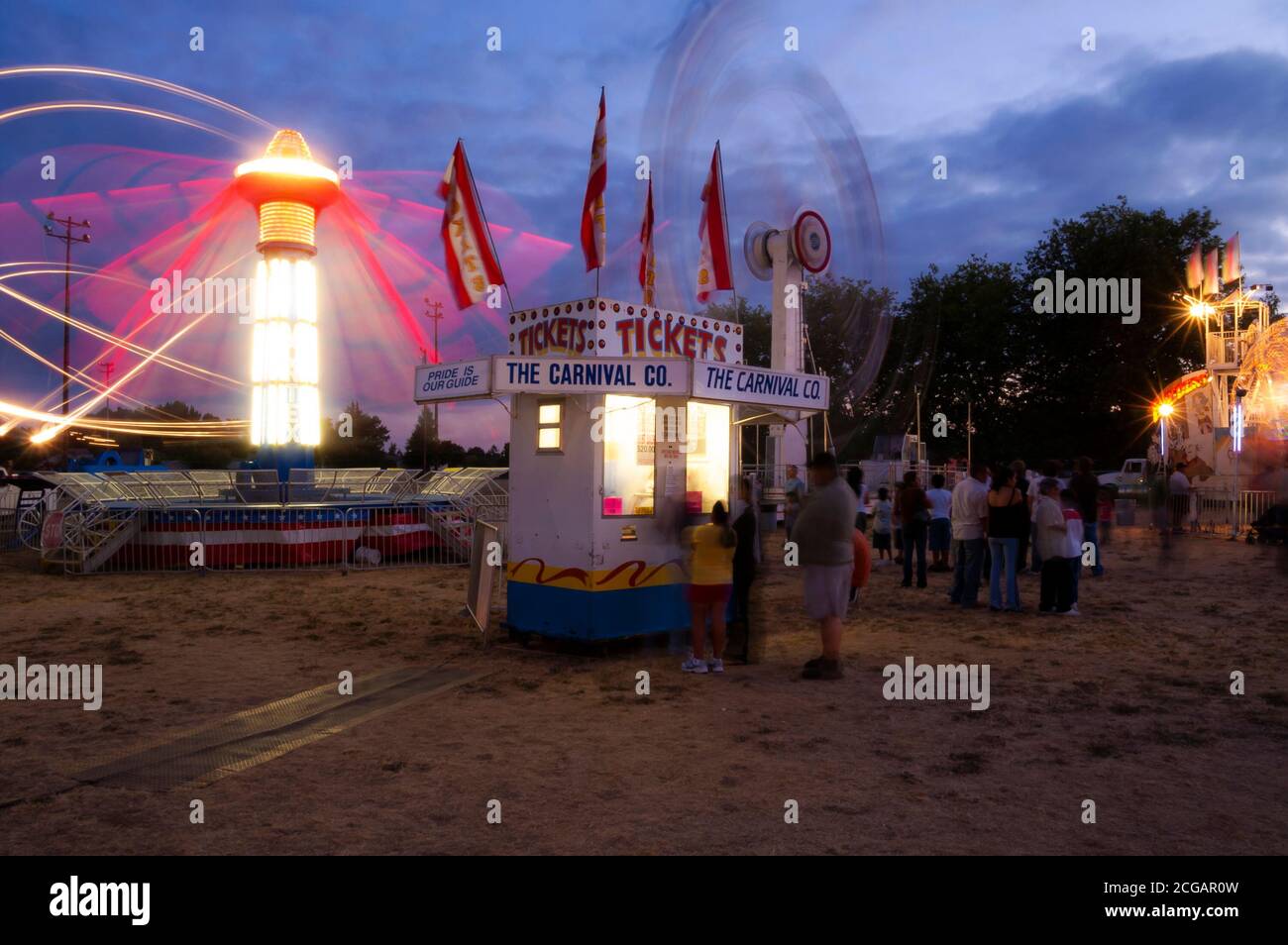 Thrill rides at a traveling carnival funfair festival blurred against ...