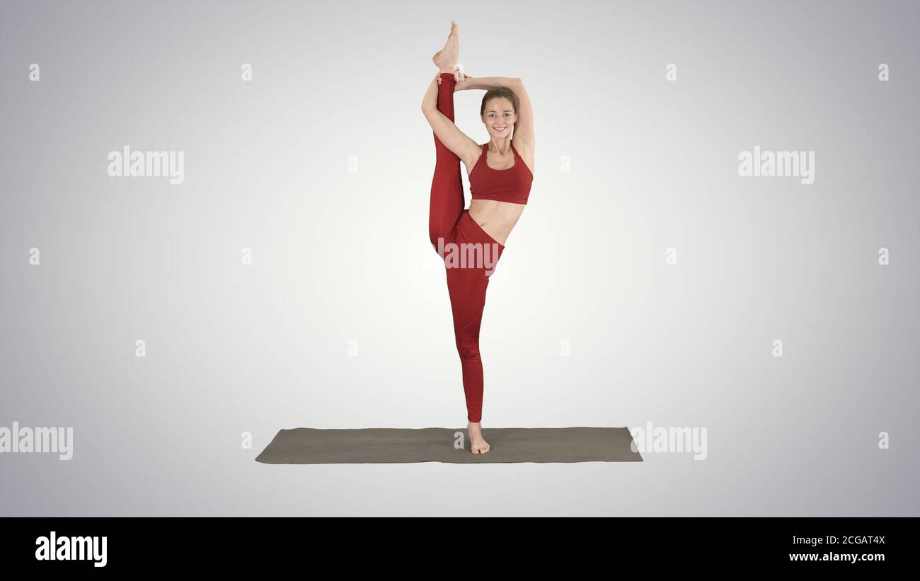 Female Yoga Model Making Standing Split Smiling on gradient background ...
