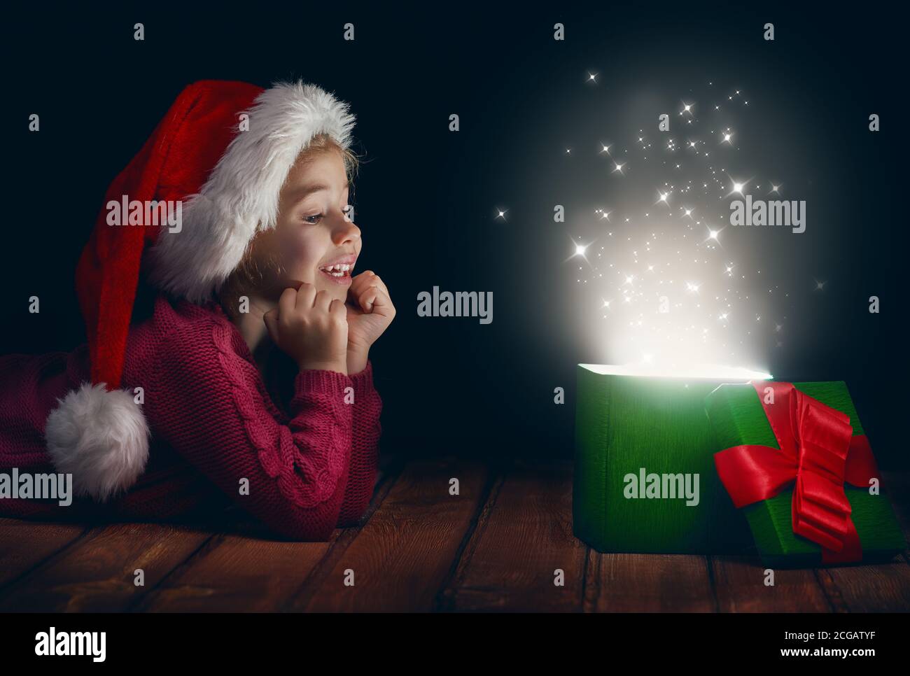 Cute little girl opening a magic gift box Stock Photo - Alamy