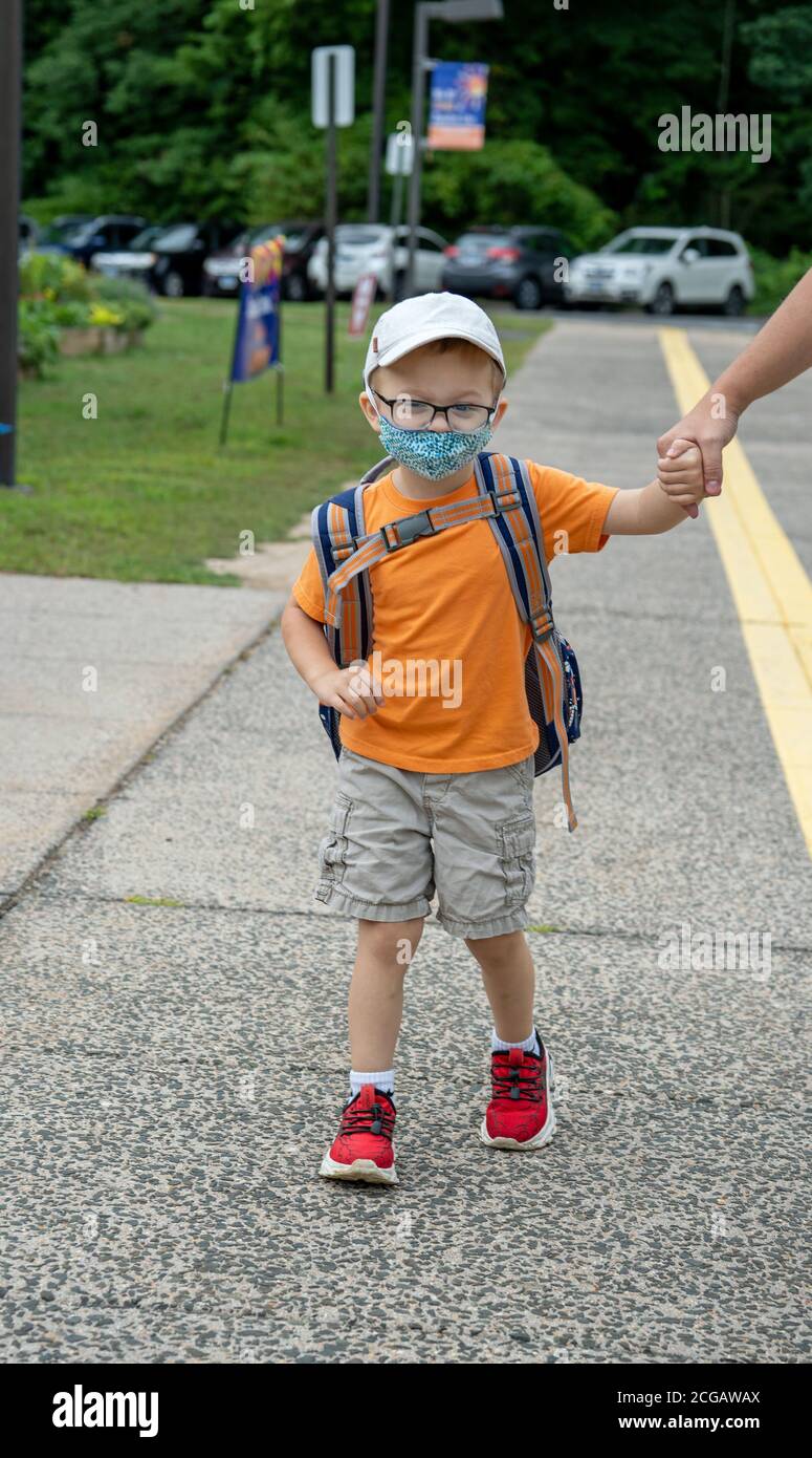 4 year old boy first day back to school wearing facial mask and ...