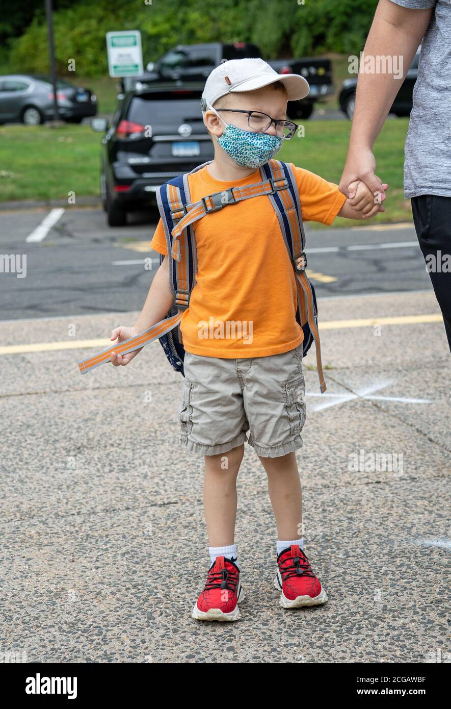 4 year old boy first day back to school wearing facial mask and ...
