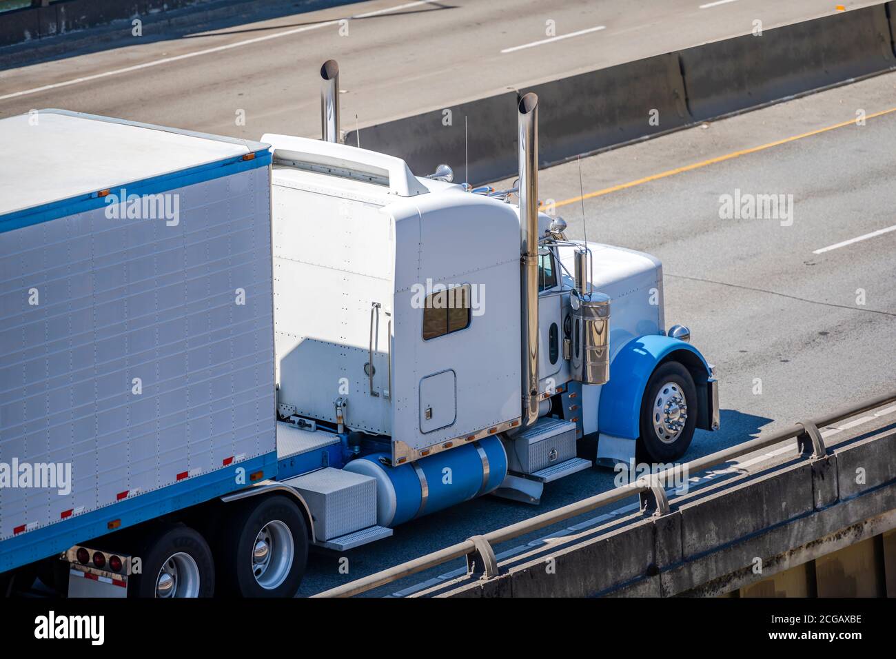 Powerful white classic big rig diesel semi truck transporting frozen ...