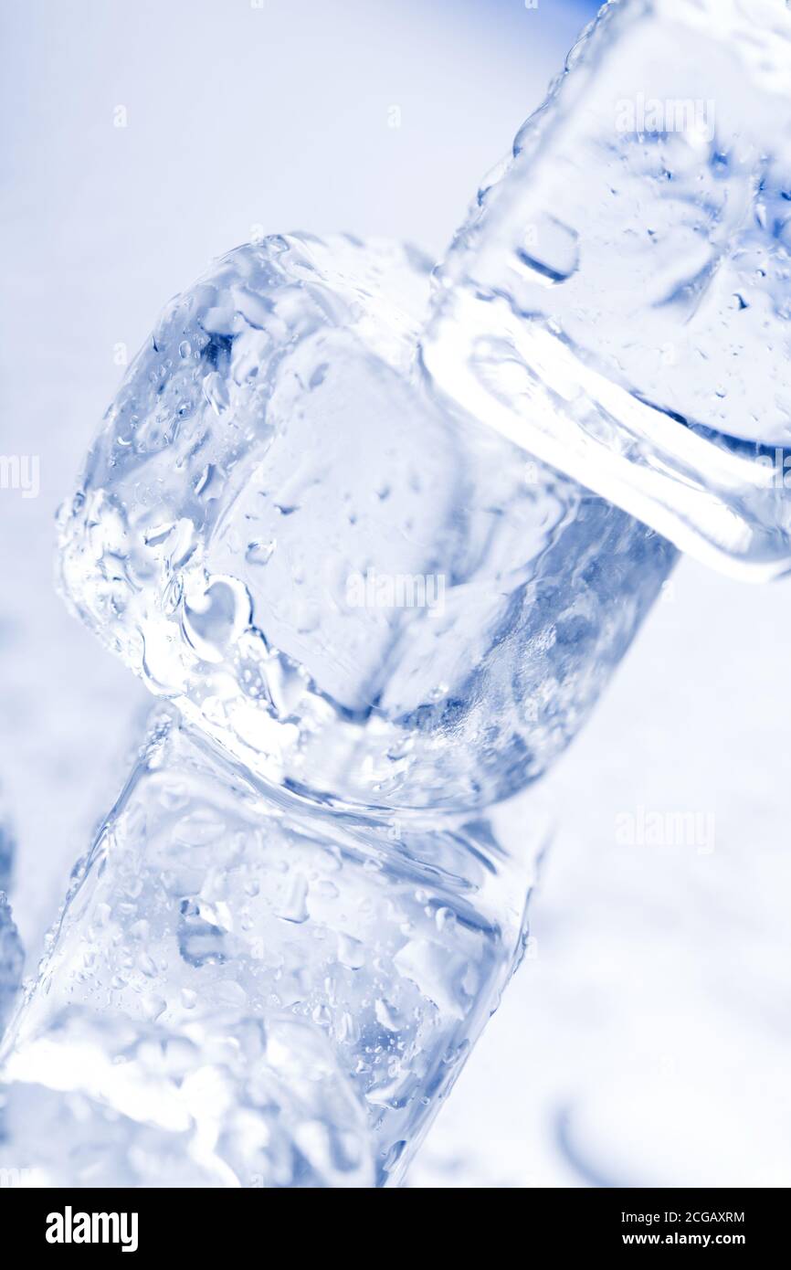 Three melting ice cubes on bright background Stock Photo - Alamy