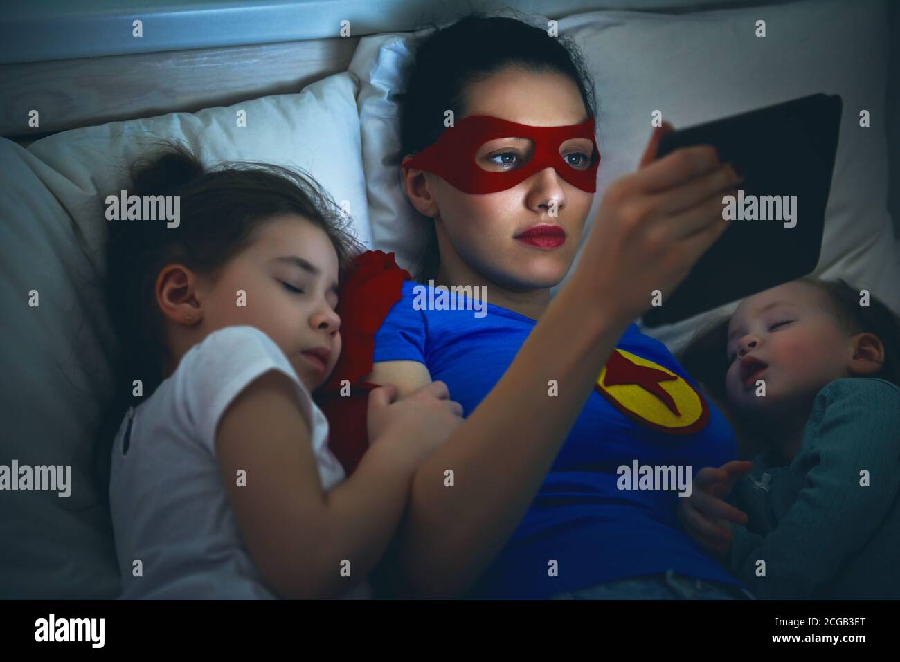 Adorable little children girls are napping in the bed with their mom ...