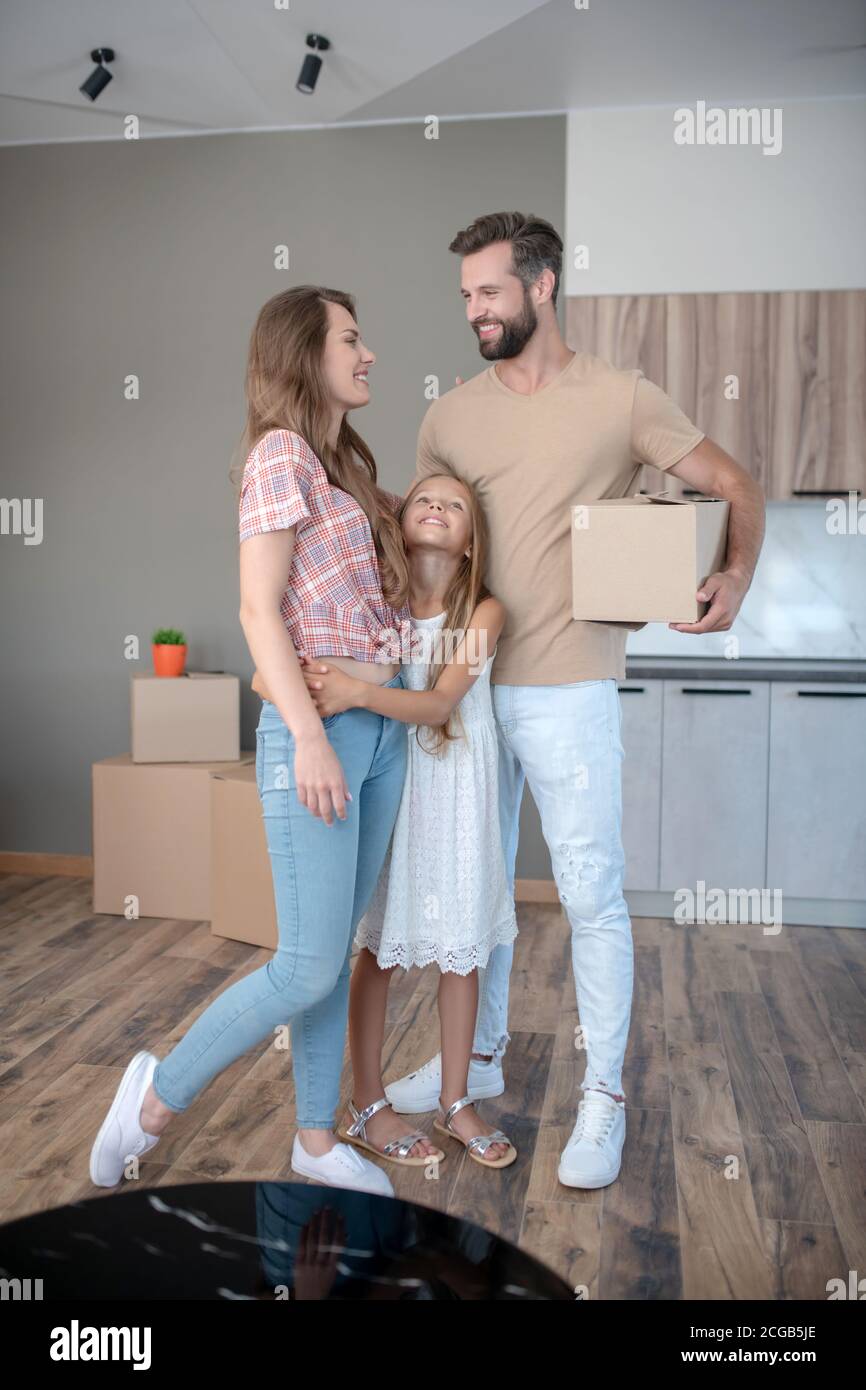 Young cute family standing in their new house Stock Photo - Alamy