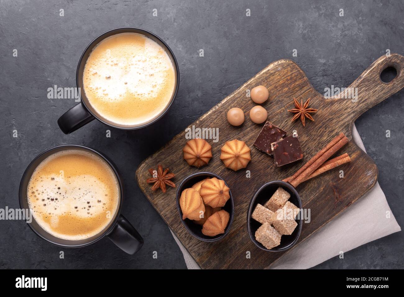 Two cups with coffee, brown sugar and various sweets on stone ...