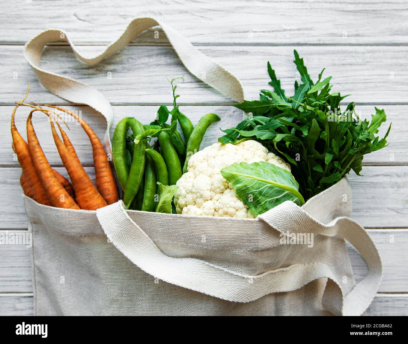 Fresh vegetables in eco cotton bags on table in the kitchen. Carrot ...