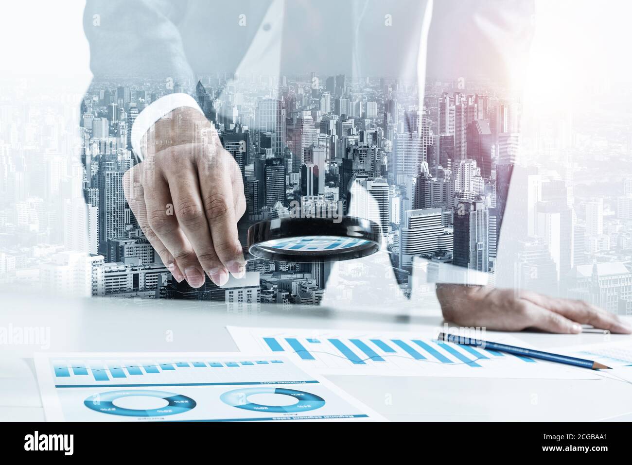 Man analyzing documents with magnifying glass Stock Photo - Alamy