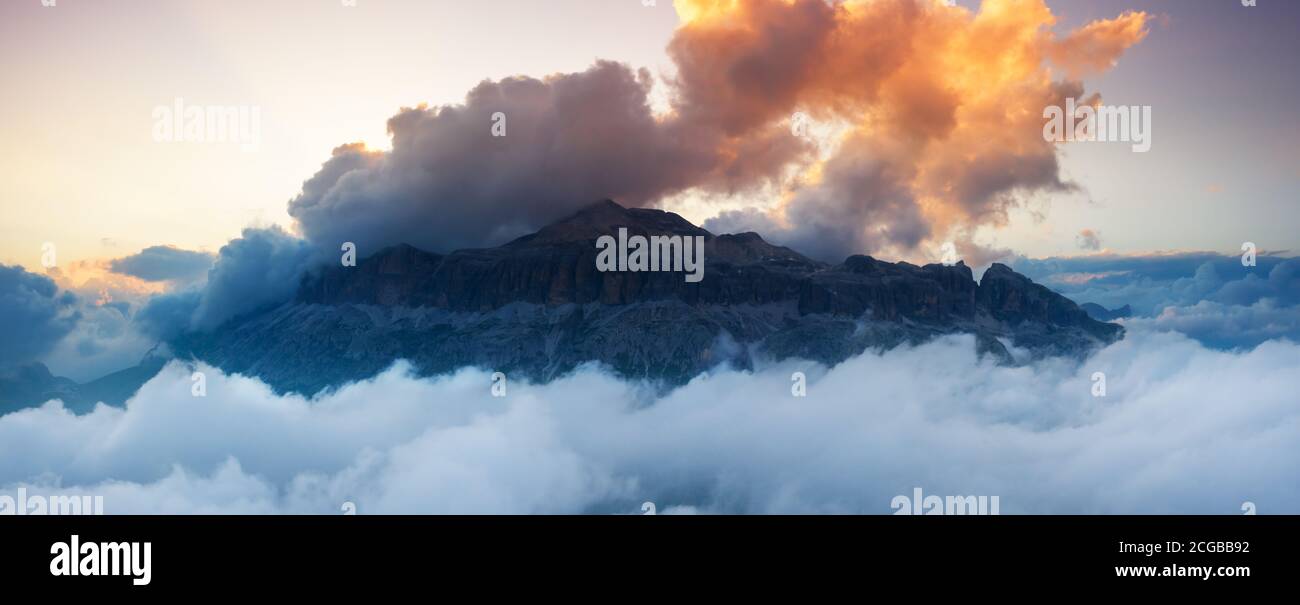 Aerial view above clouds of massive rock of Dolomites mountain, Italy ...