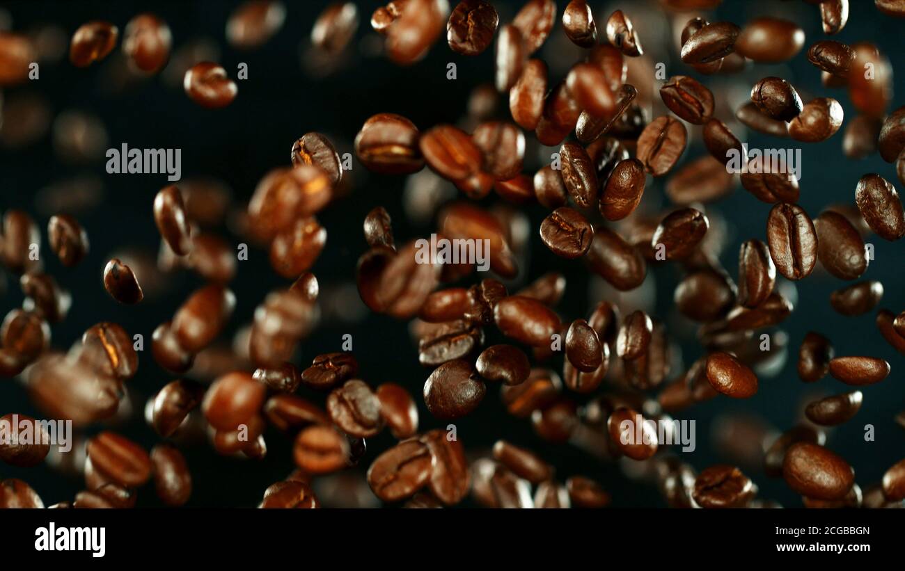 Fresh roasted coffee beans flying in the air, isolated on black ...