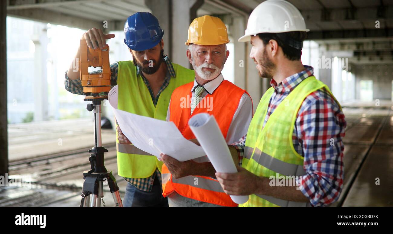 Male architects analyzing blueprint at construction site Stock Photo ...