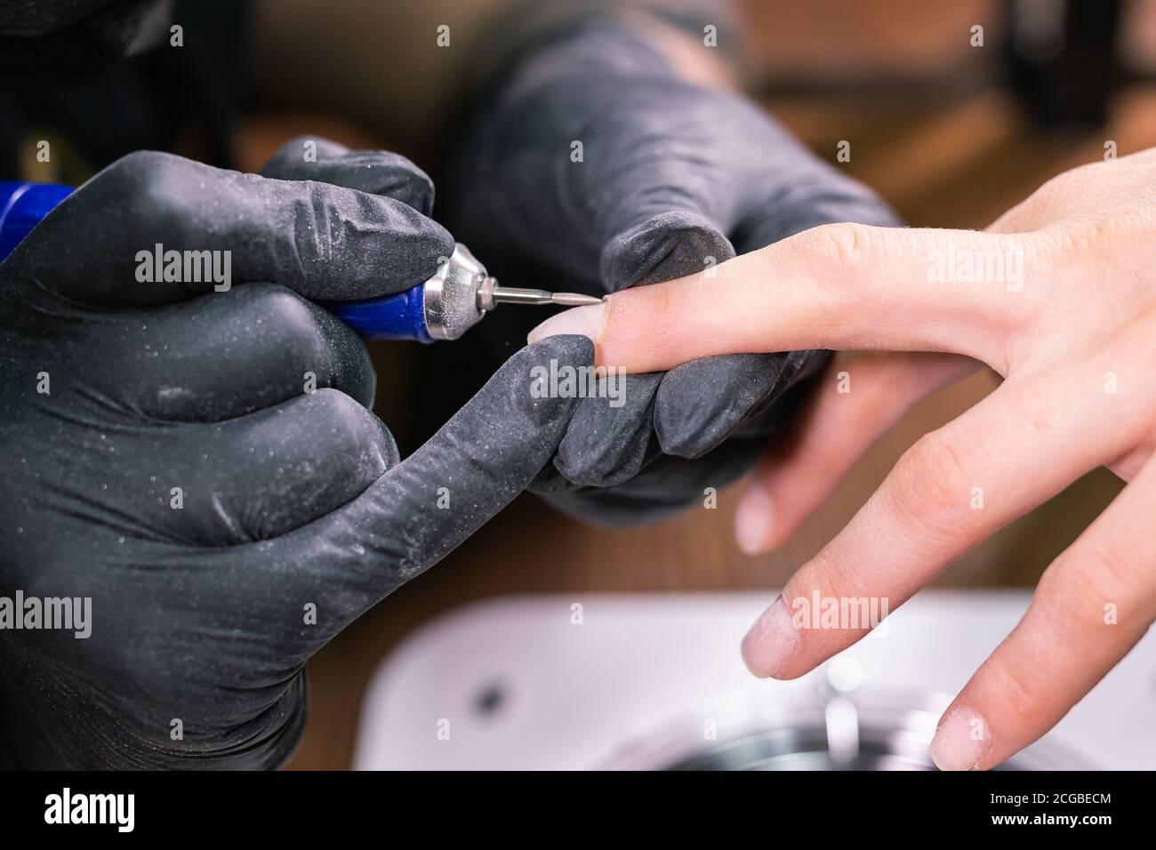 Hardware manicure in a beauty salon. Female manicurist is applying ...