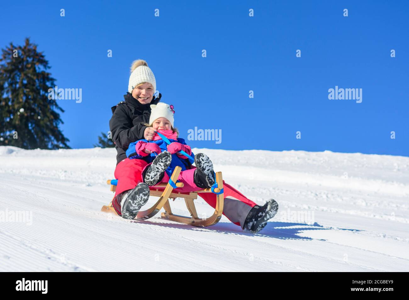 Family fun on sleigh run in snow Stock Photo - Alamy