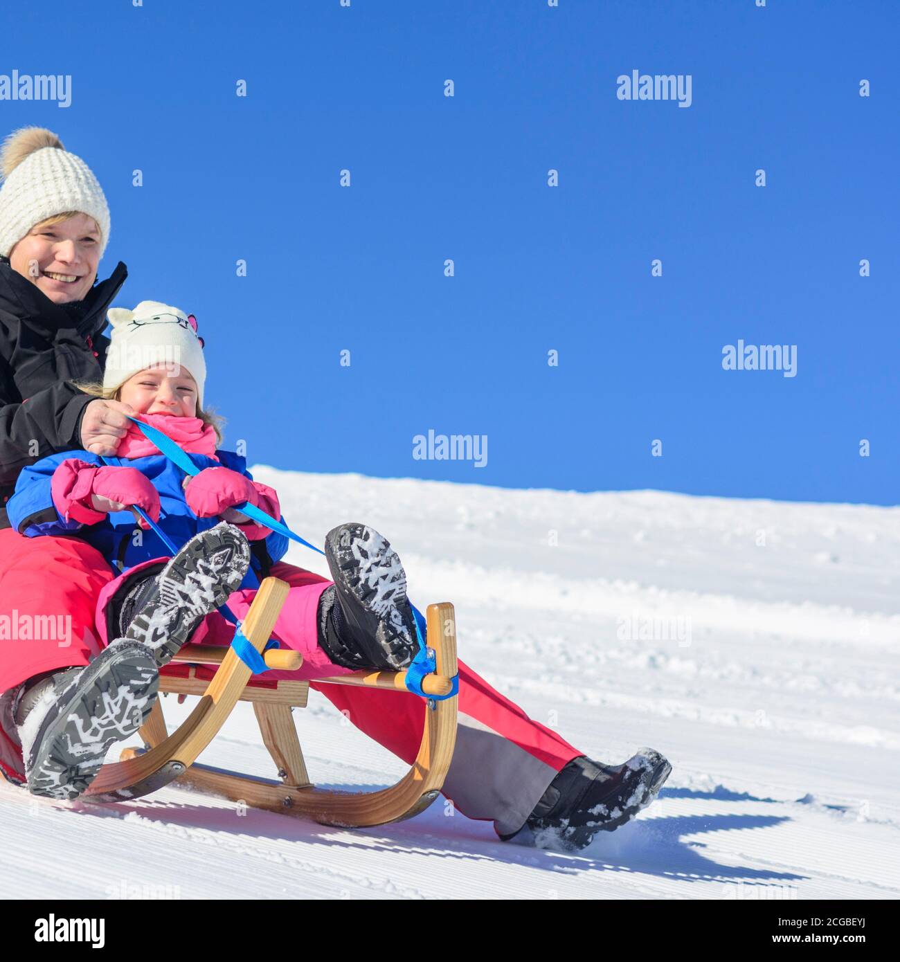 Family fun on sleigh run in snow Stock Photo - Alamy