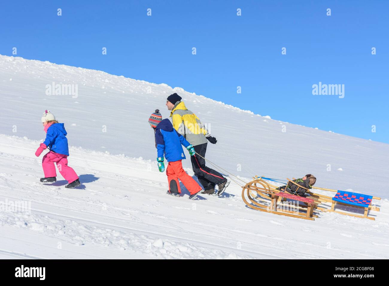 Family fun on sleigh run in snow Stock Photo - Alamy