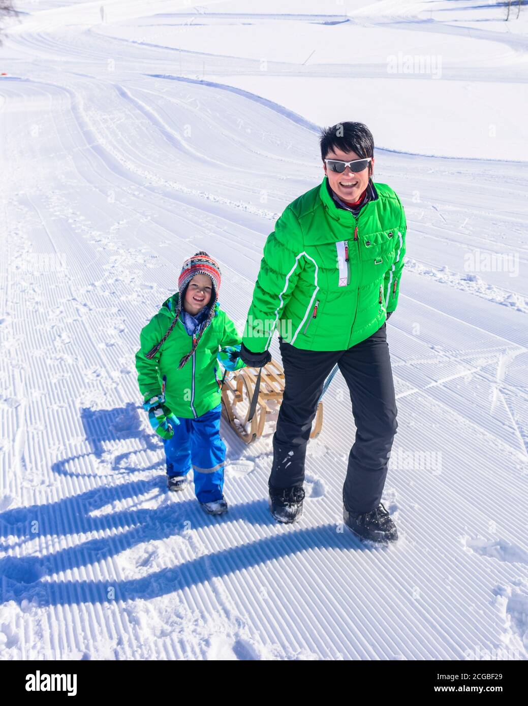 Family fun on sleigh run in snow Stock Photo - Alamy
