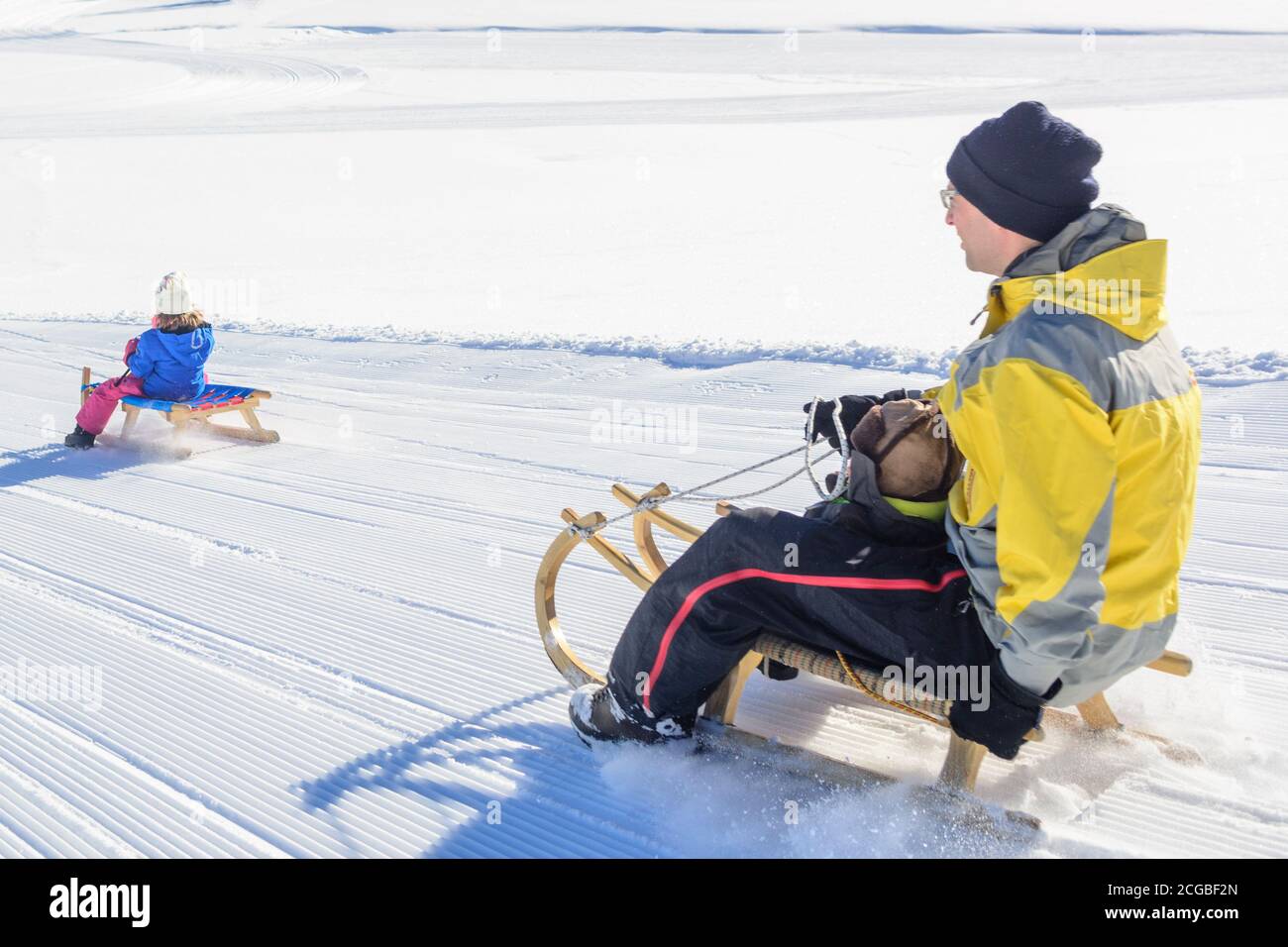 Family fun on sleigh run in snow Stock Photo - Alamy