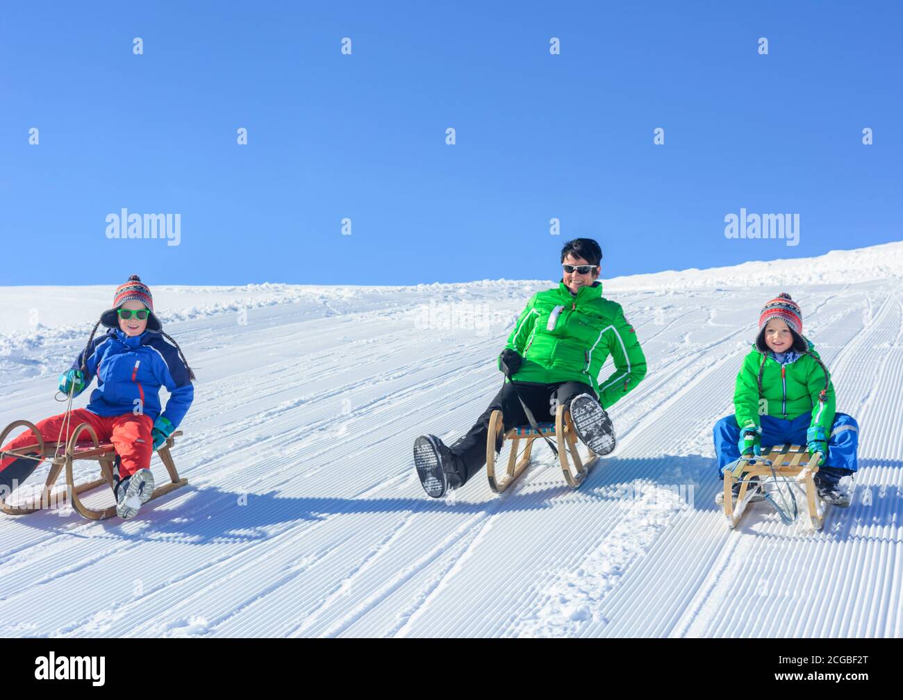 Family fun on sleigh run in snow Stock Photo - Alamy