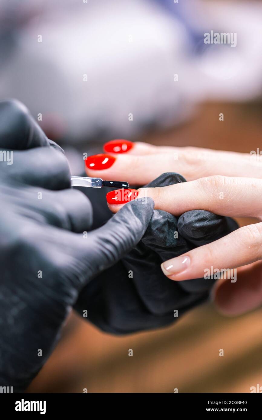 Master applied varnish drawing on nails gel in manicure salon, close-up ...