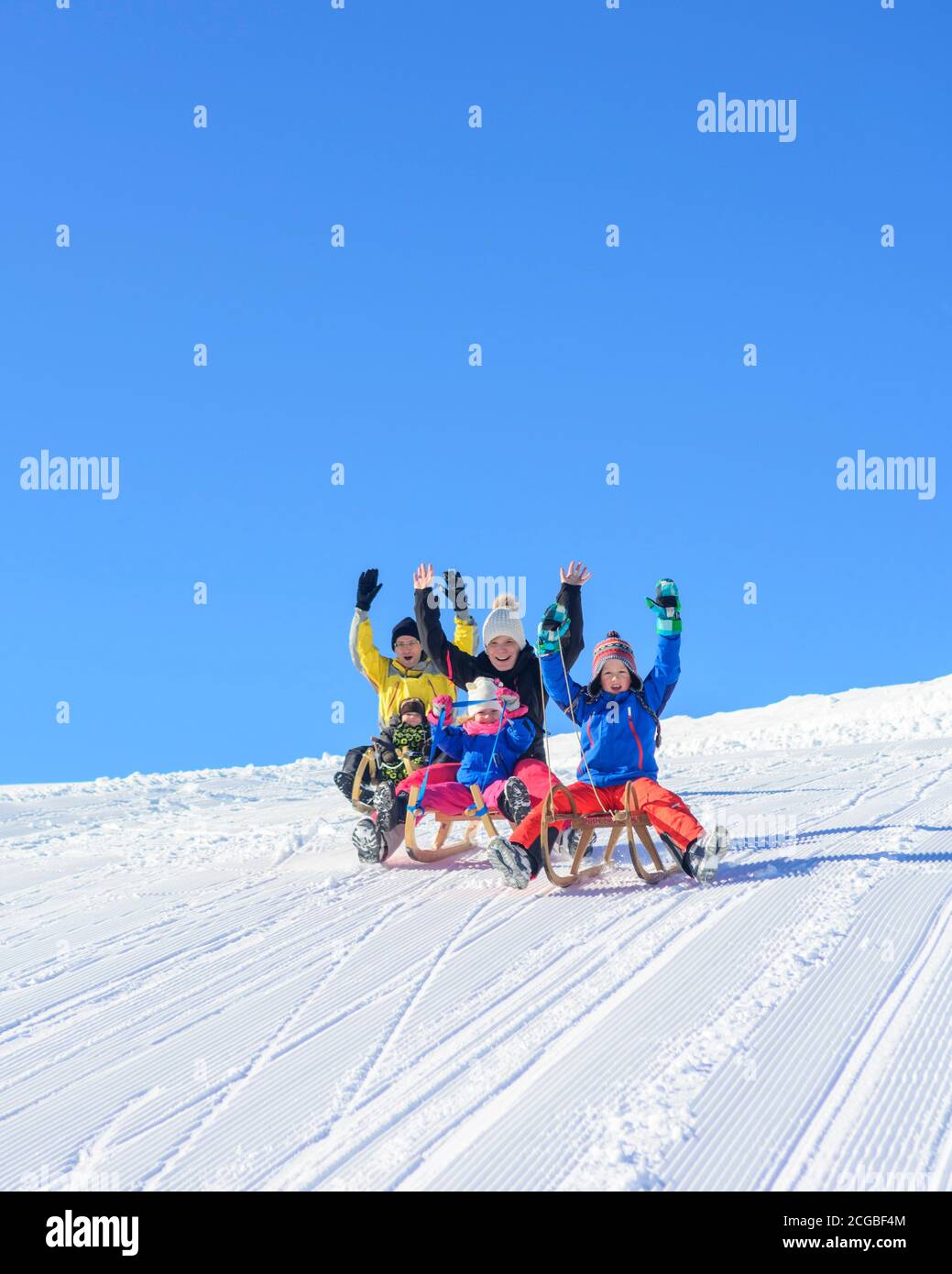 Family fun on sleigh run in snow Stock Photo - Alamy