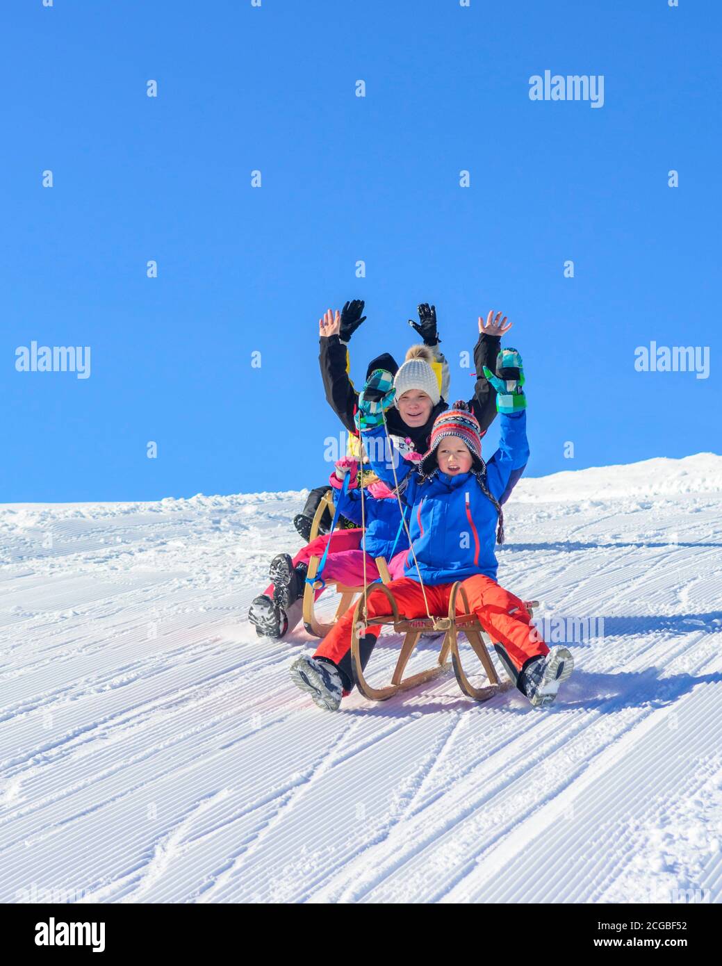Family fun on sleigh run in snow Stock Photo - Alamy
