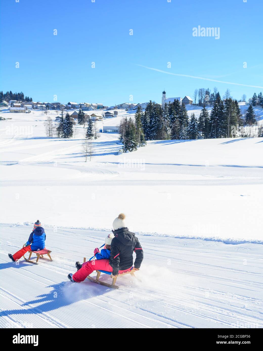 Family fun on sleigh run in snow Stock Photo - Alamy