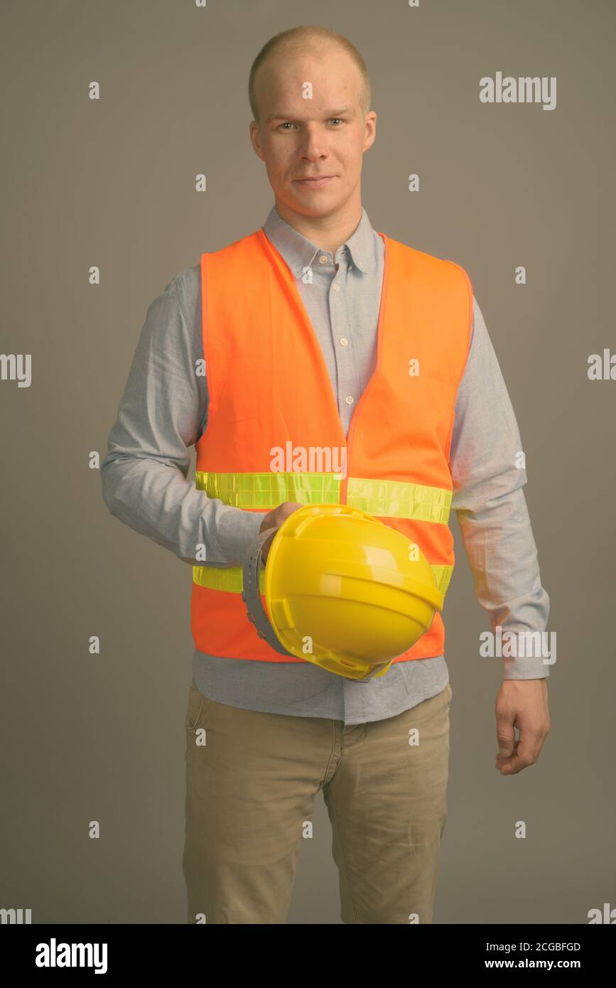 Bald man construction worker against gray background Stock Photo - Alamy