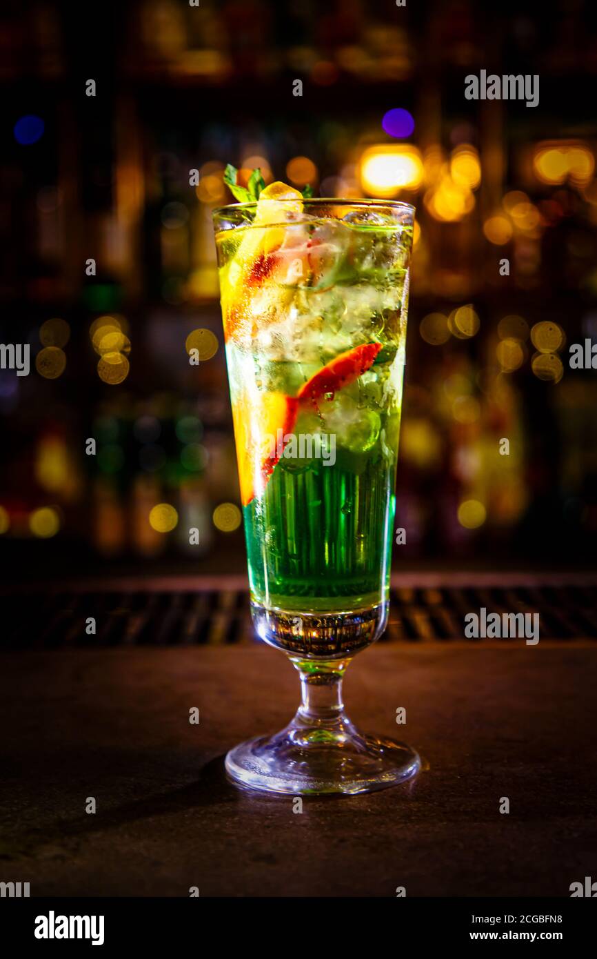 A green cocktail in a tall glass stands on the bar Stock Photo - Alamy