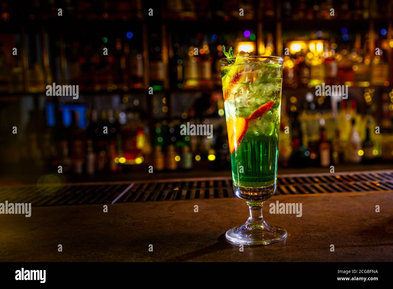 A green cocktail in a tall glass stands on the bar Stock Photo - Alamy