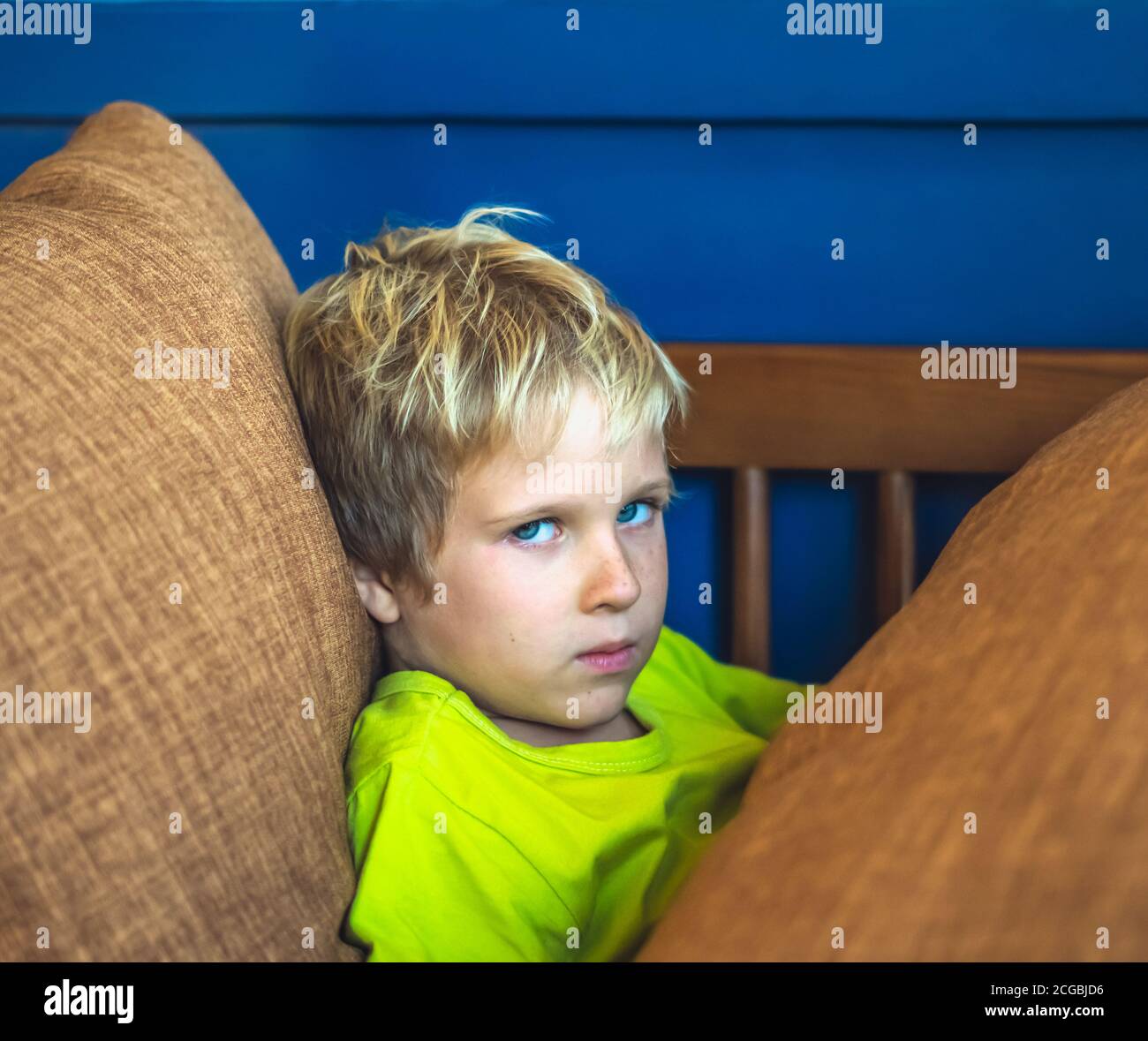 Portrait offended looking sullen blue eyed boy making freckles face in ...