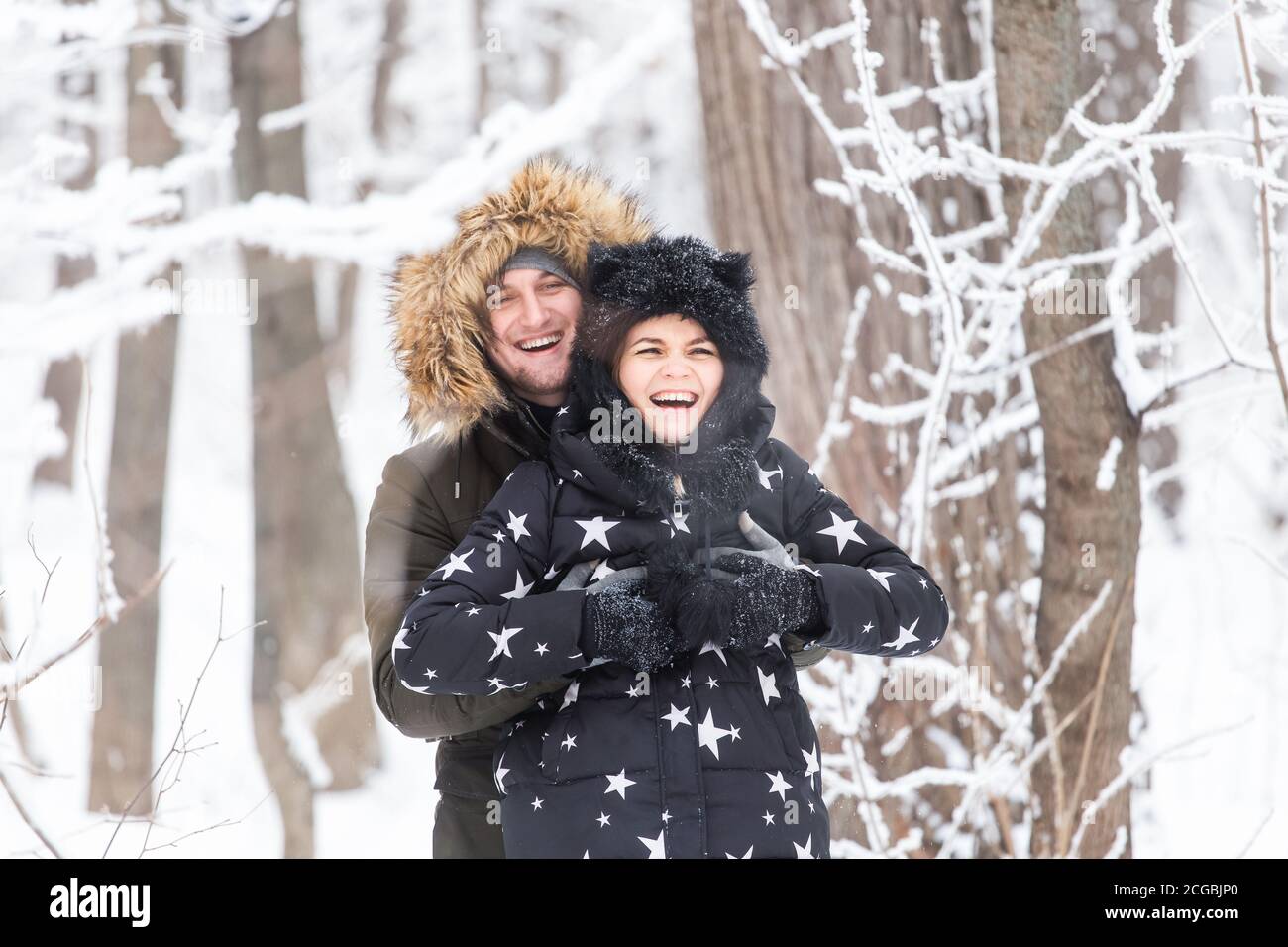 Fun, season and leisure concept - love couple plays winter wood on snow ...