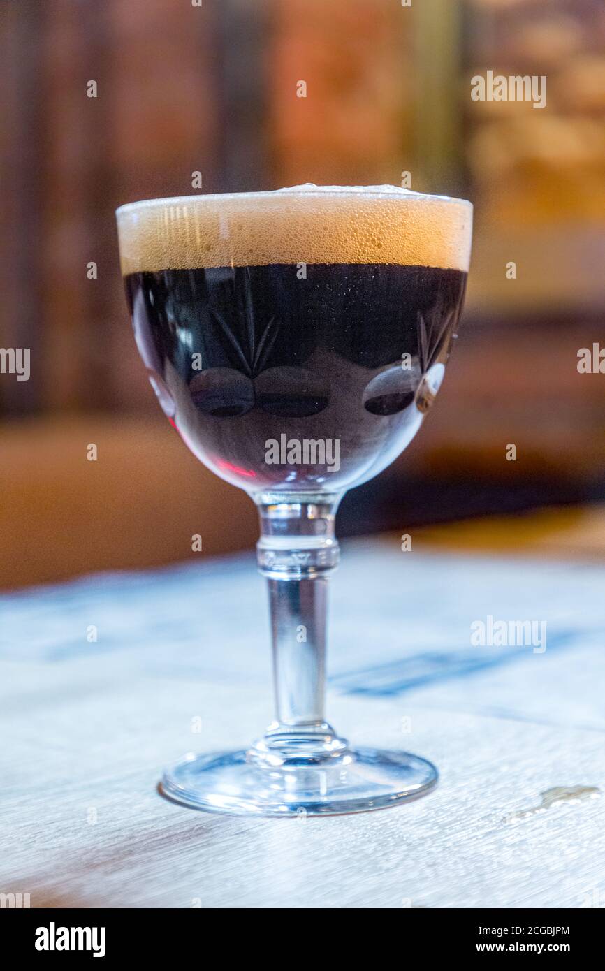 A glass of dark Belgian beer is on the table Stock Photo - Alamy