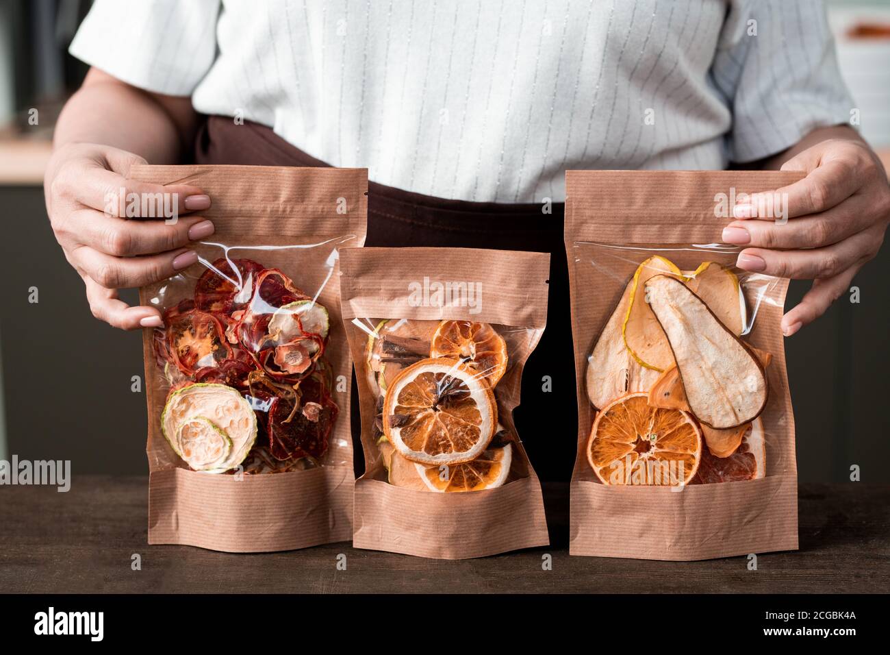 Close-up of unrecognizable woman presenting packages of sweet dried ...