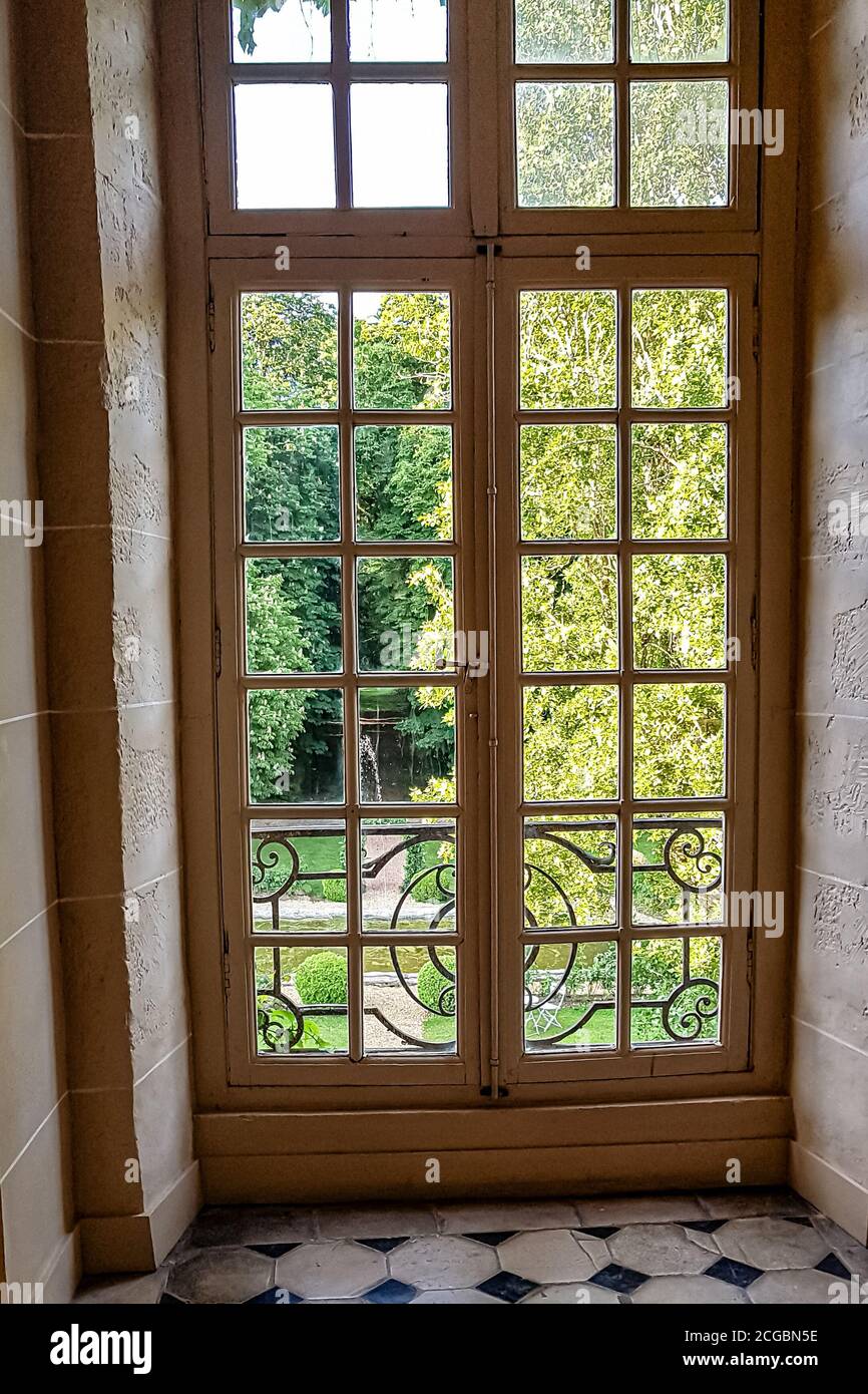 View through the window with bars on the green Park Stock Photo - Alamy