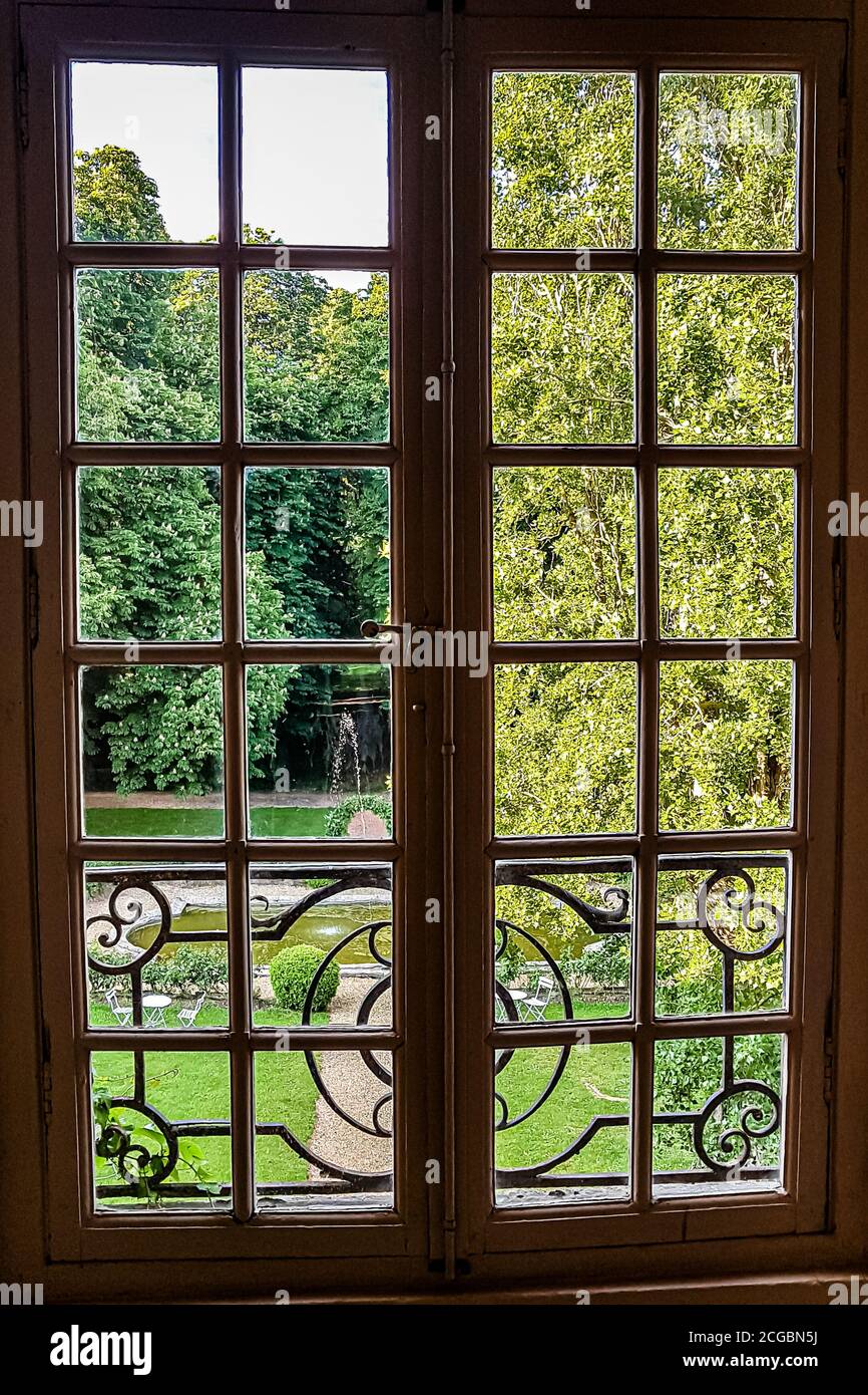 View through the window with bars on the green Park Stock Photo - Alamy