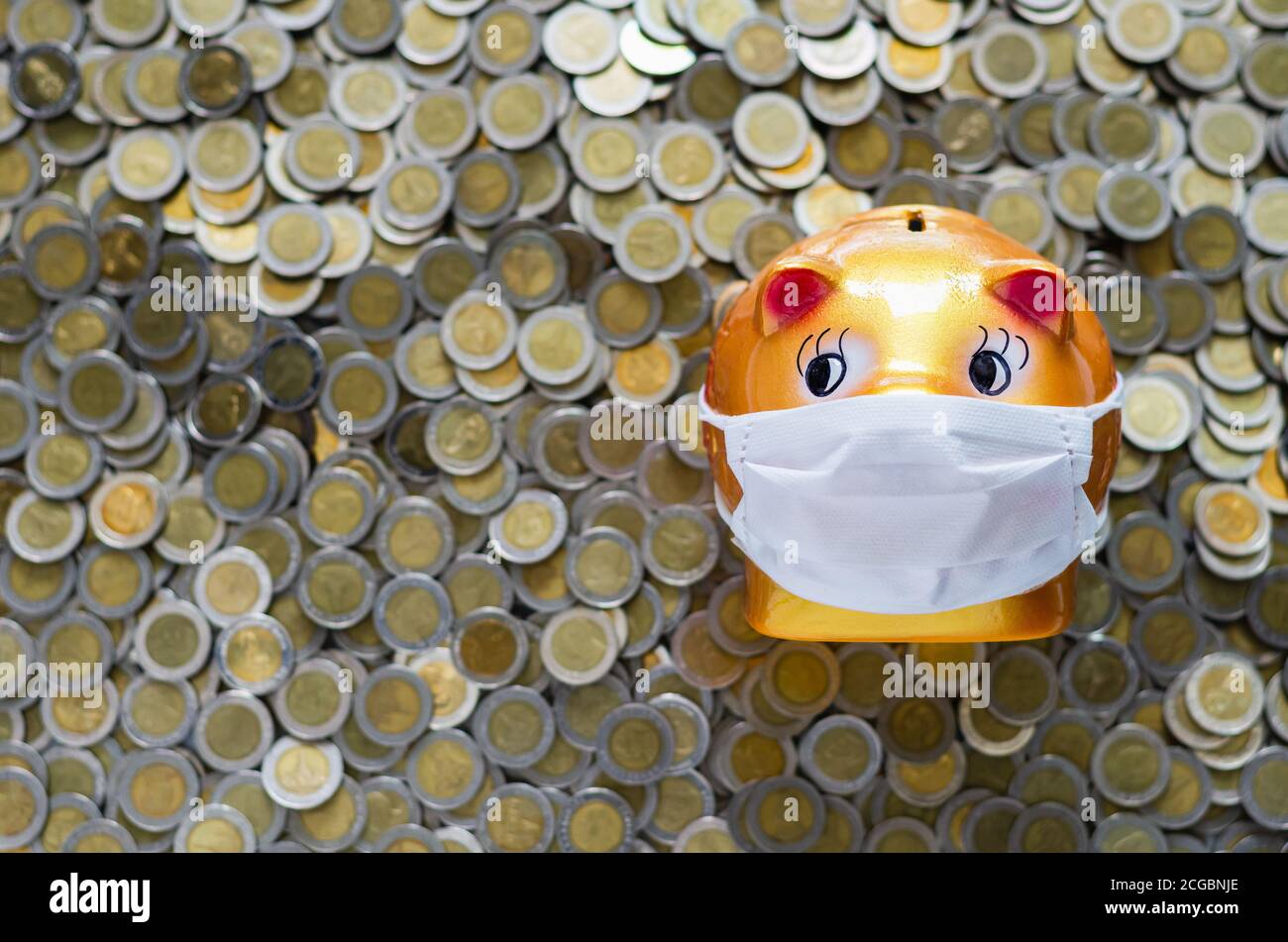 Piggy bank wearing white face mask on blurred background of Thai baht ...