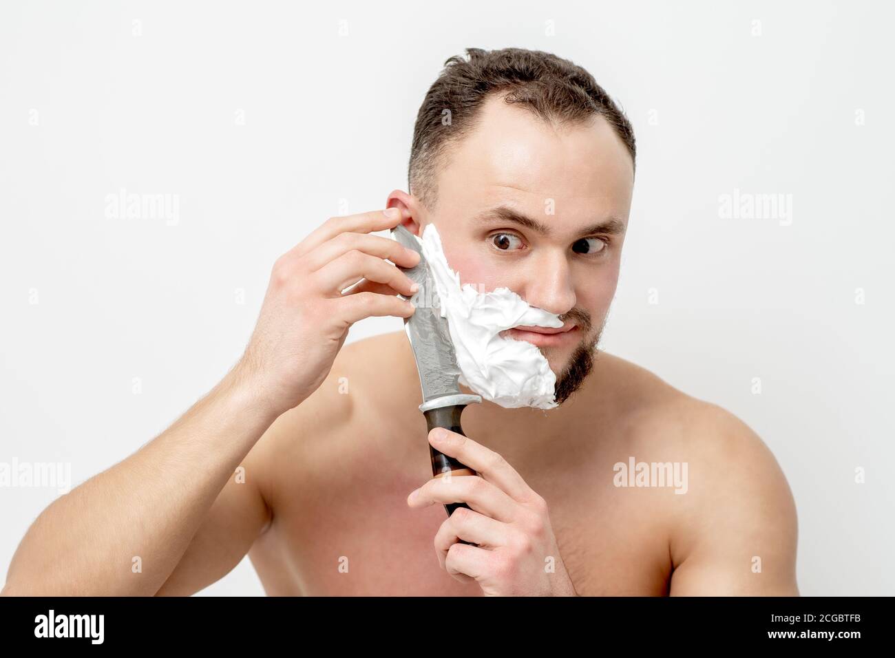 Young caucasian man shaving beard with knife on white background Stock ...