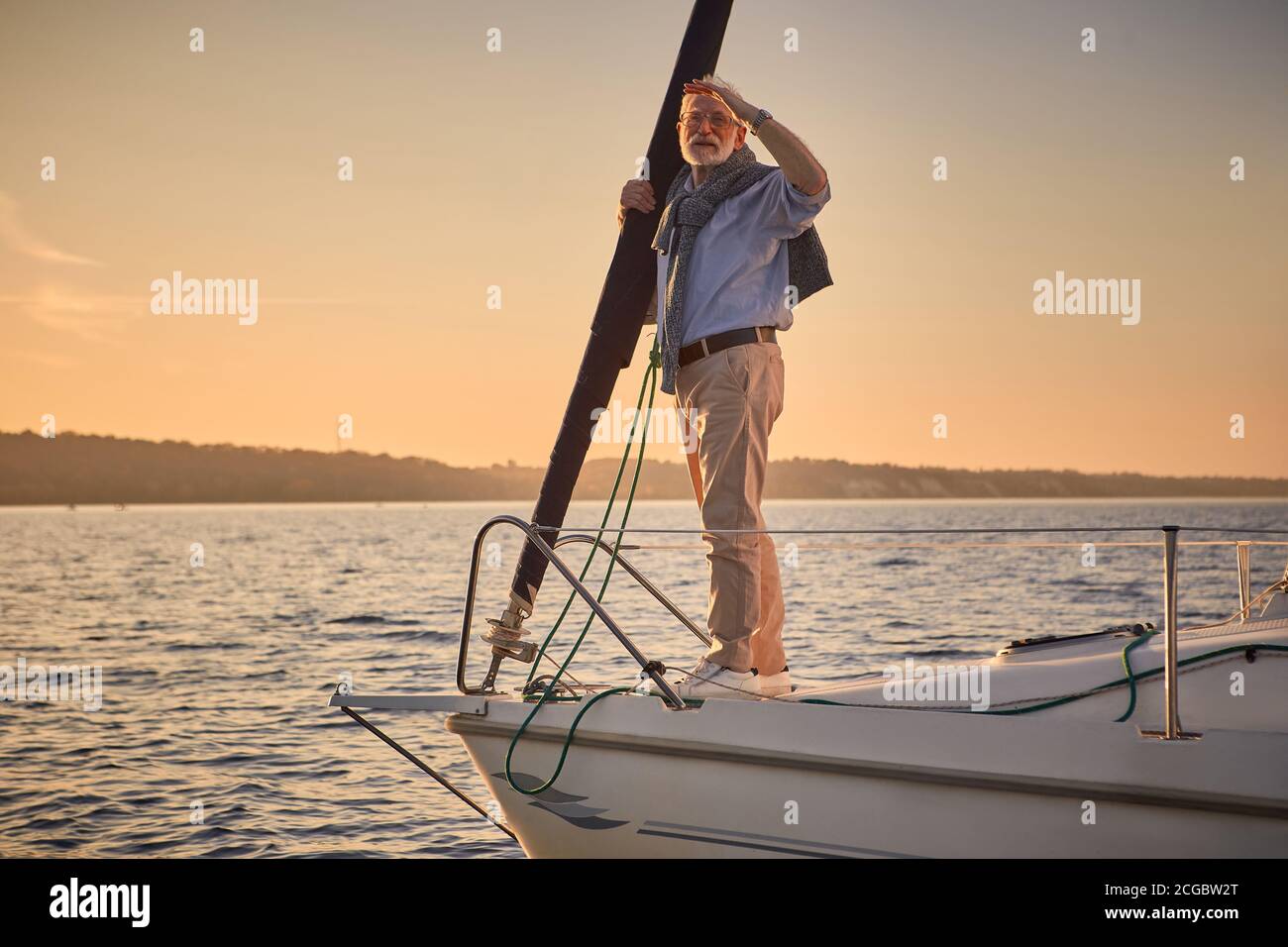 Sailing man on yacht. Elegant senior man standing on the side of a ...