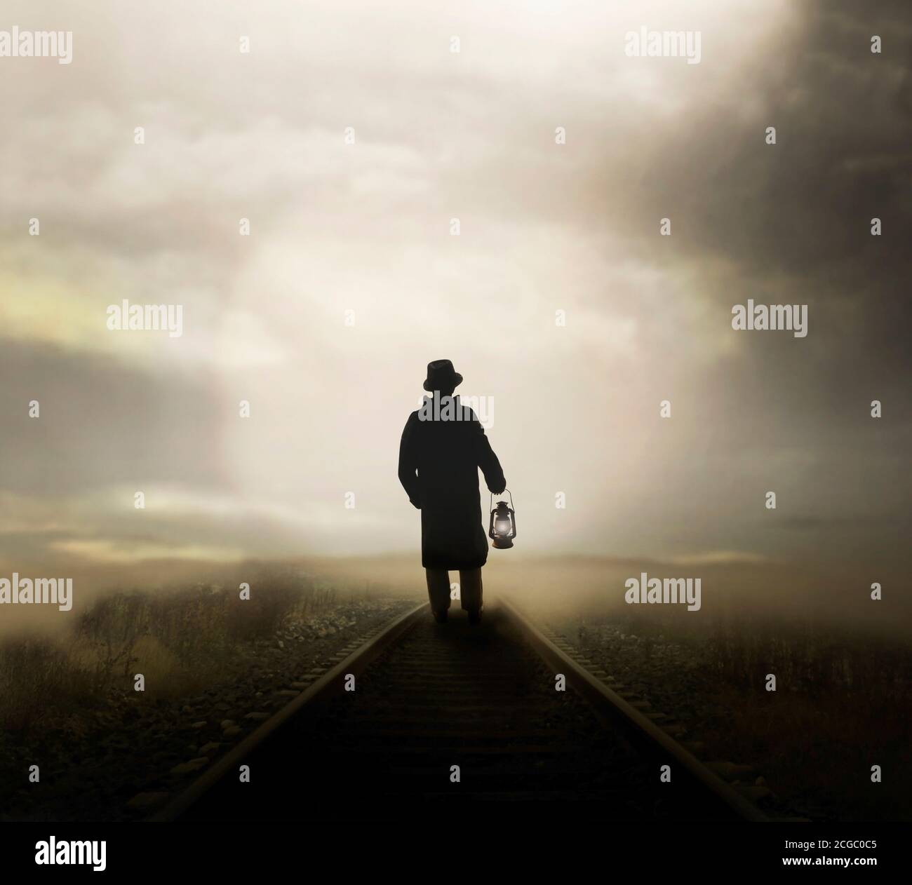 man walks on the rail road with a lantern following the light that ...