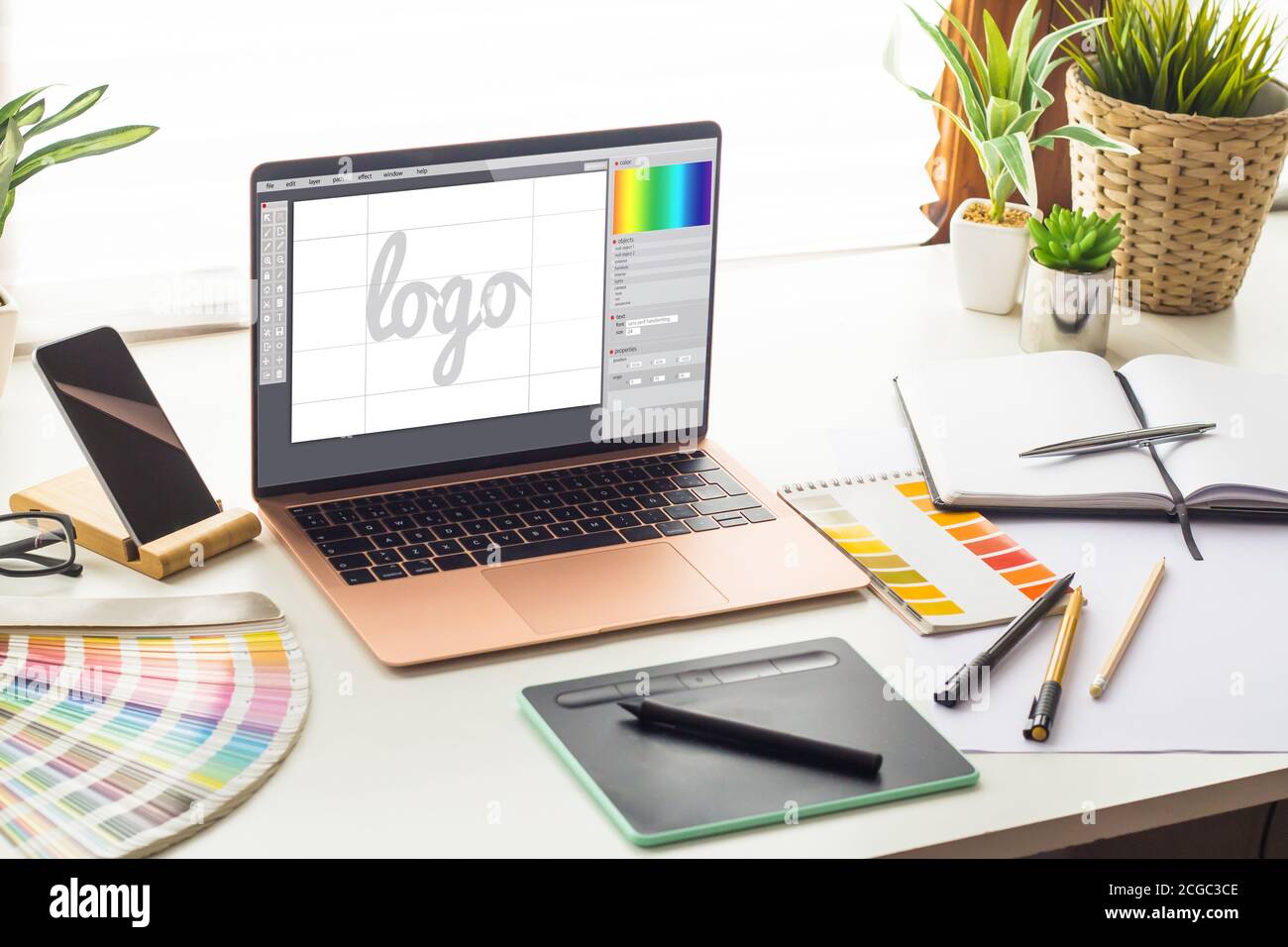Graphic design studio with logo design on laptop screen Stock Photo - Alamy