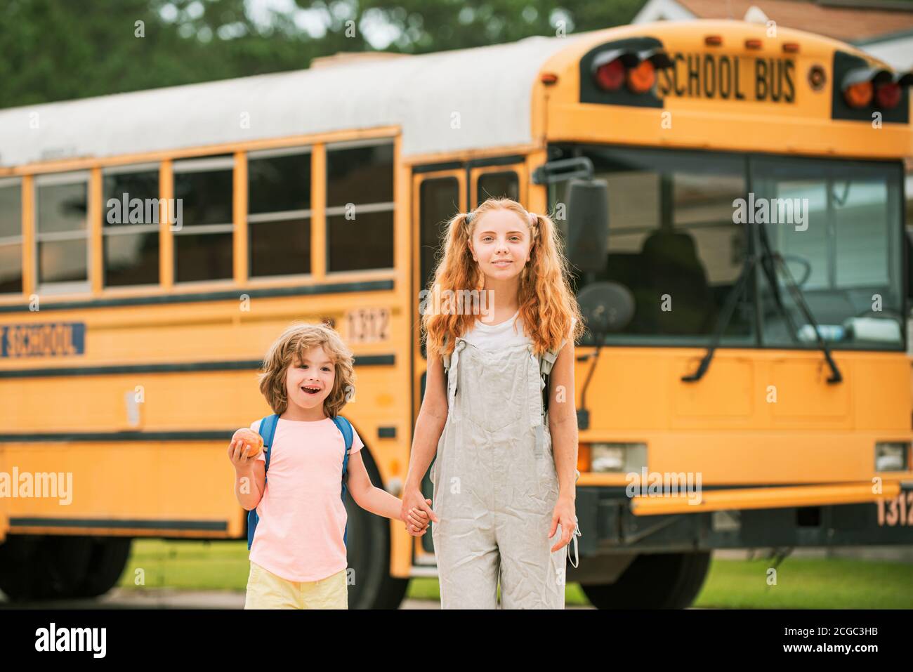 A group of young children getting on the schoolbus Stock Photo - Alamy