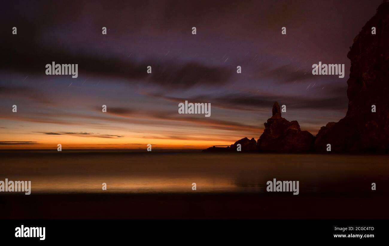 Piha beach at dusk with star trails and last sunset colours Stock Photo ...