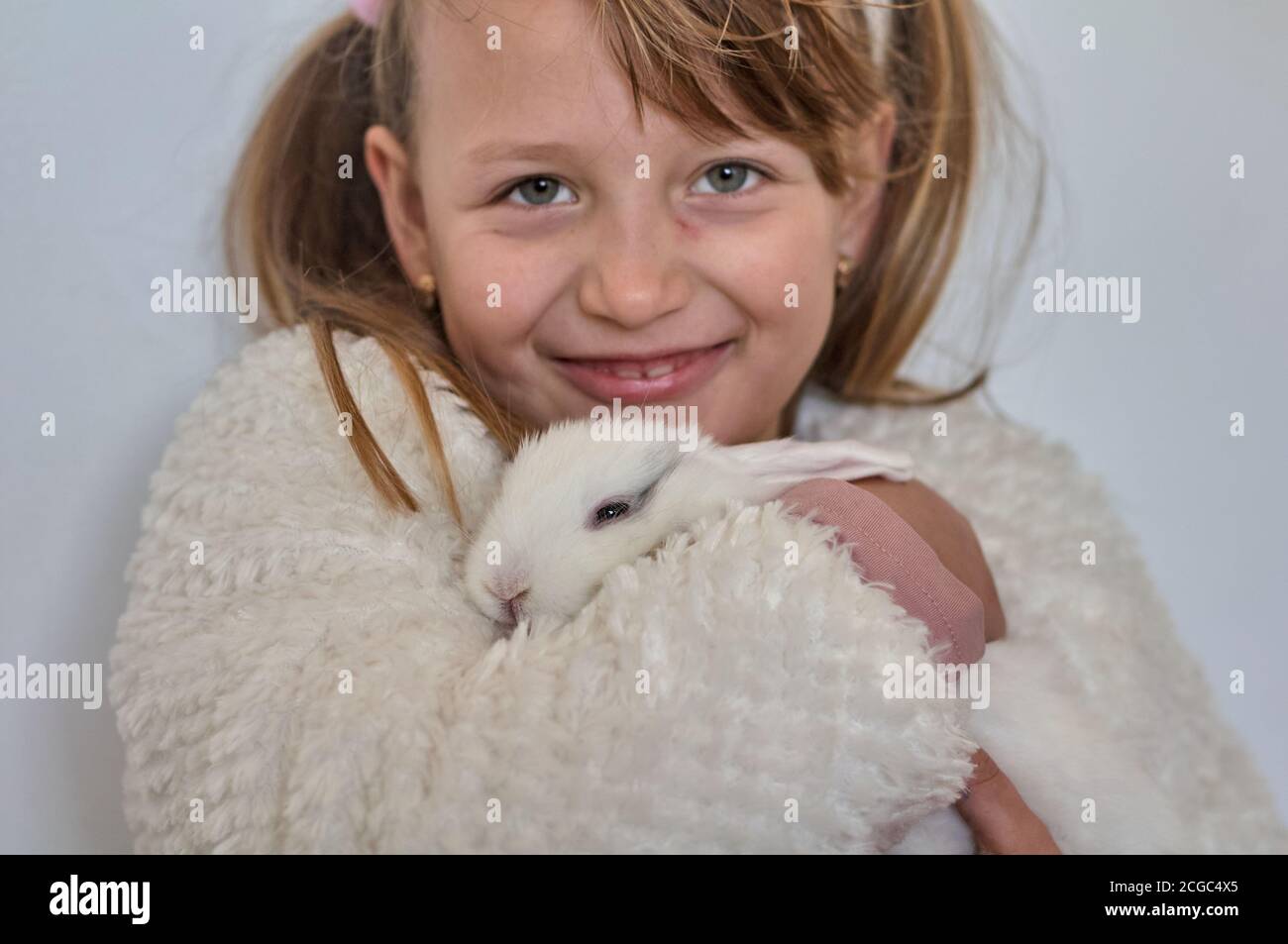 blonde girl with a white rabbit in her arms Stock Photo - Alamy