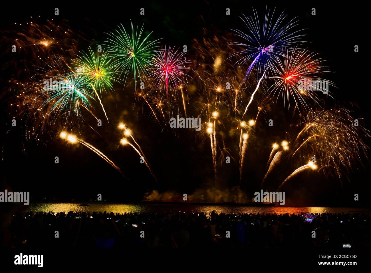 People capturing a fireworks shows with their mobile phone. Colorful ...