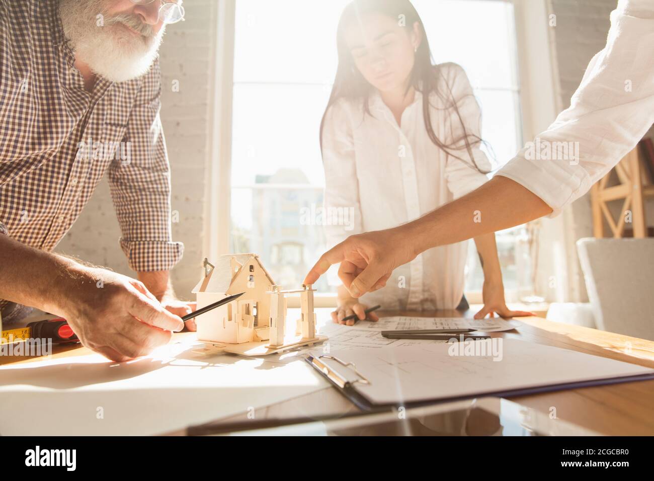 Hands of architect-engineer and young couple during presentation of ...