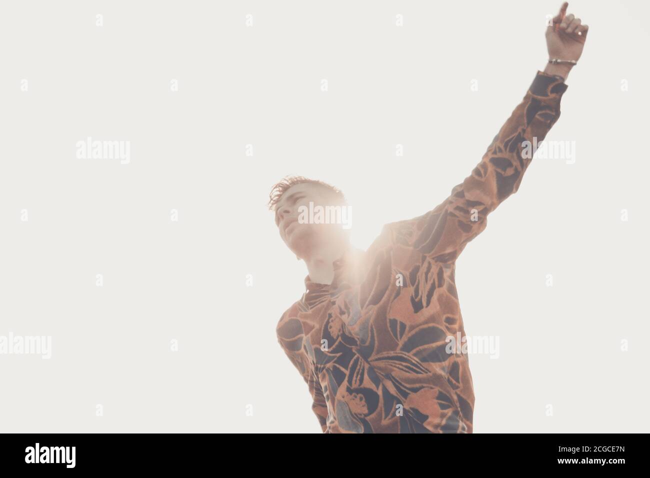 Boy with one arm raised against light with a very hi-res stock ...